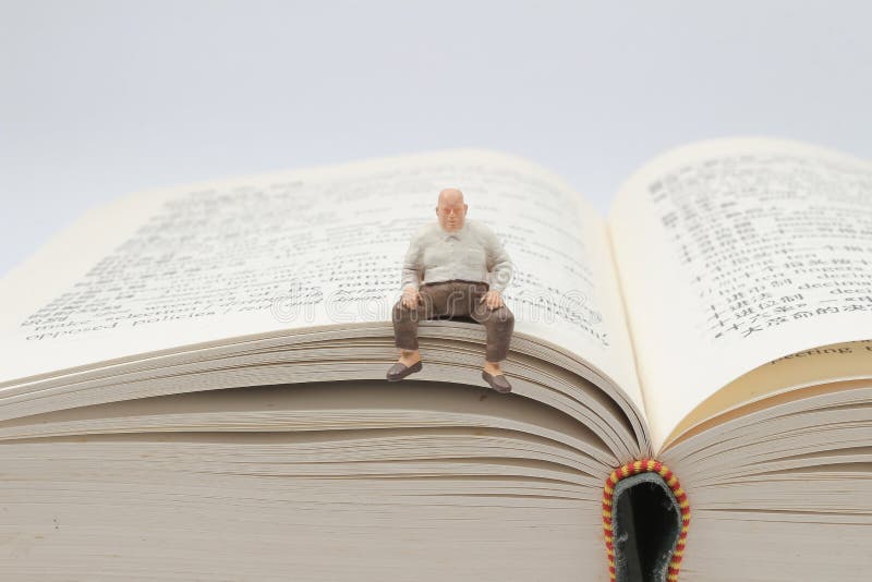 A Fun of Mini People:figure Sitting on Book Stock Photo - Image of ...