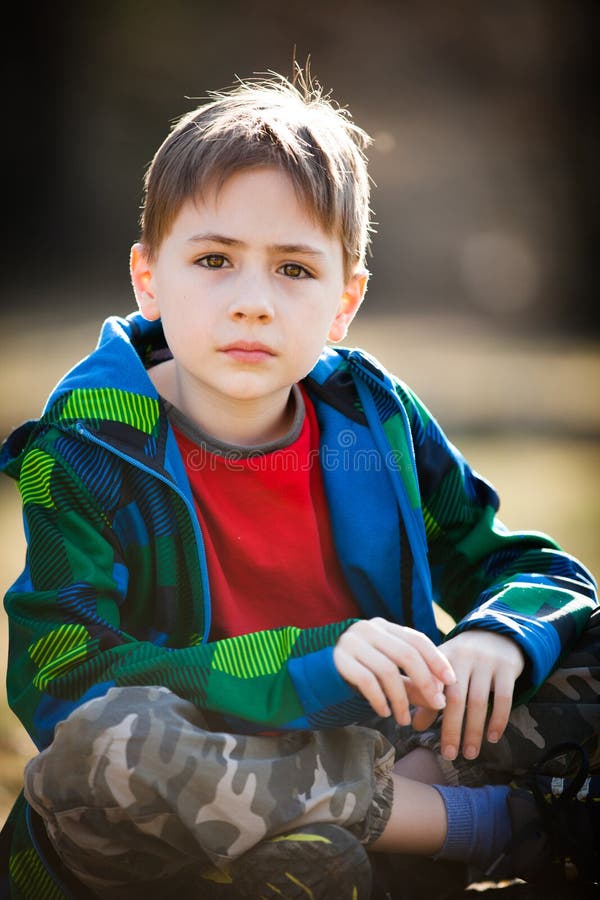 Fundersam ung pojke fotografering för bildbyråer. Bild av sittande ...