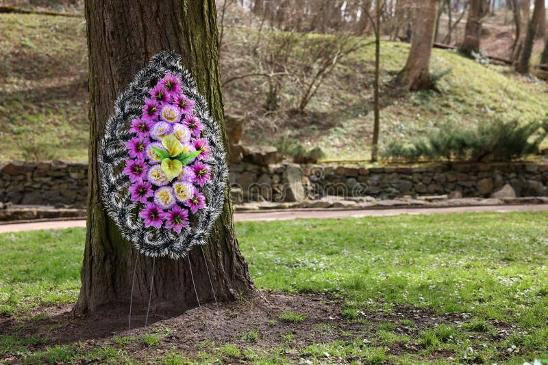 Funeral Wreath of Plastic Flowers on Tree Outdoors Stock Photo - Image ...
