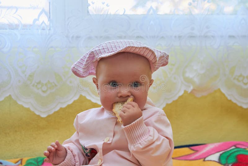 Funny Baby Eating Bread,funny Baby Girl in a Hat Bites Bread Stock ...