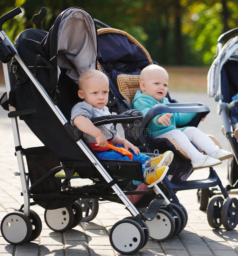 Funny Children Sitting in Strollers in Park Stock Photo - Image of ...
