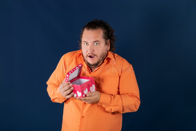 Funny Fat Man in Orange Shirt Opens a Box with a Gift Stock Image ...