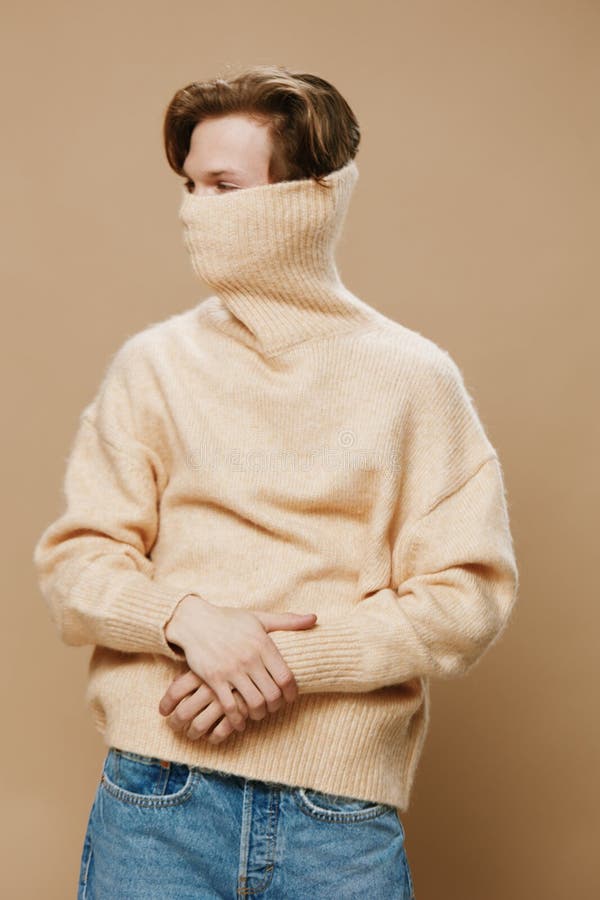 Funny Guy in a Beige Sweater with a High Neck Posing on a Plain ...