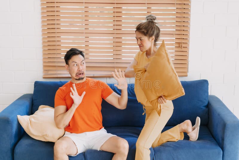 Funny Husband and Wife Fighting on the Sofa in the House. Stock Photo ...