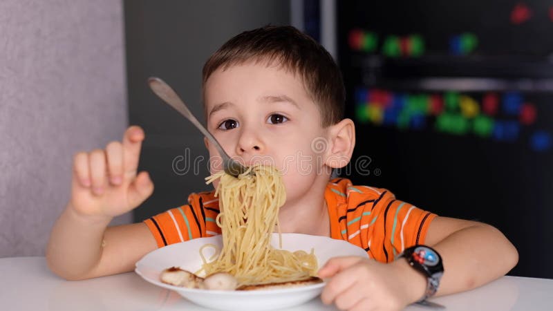 Funny Little Boy Eat Pasta in the Kitchen Table. Stock Image - Image of ...