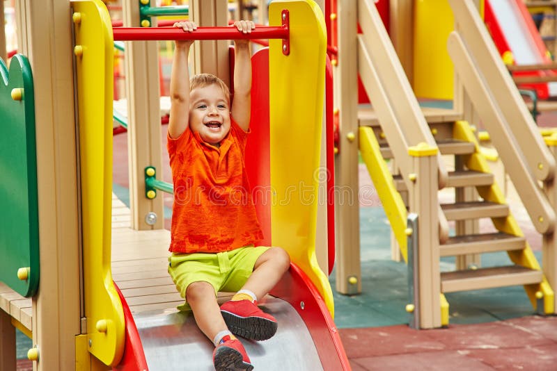 Funny Little Boy on Playground. Playing Child on Slide. Stock Photo ...