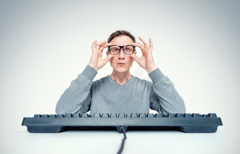 Funny Man Holds Glasses in His Hands while Sitting at a Keyboard in ...