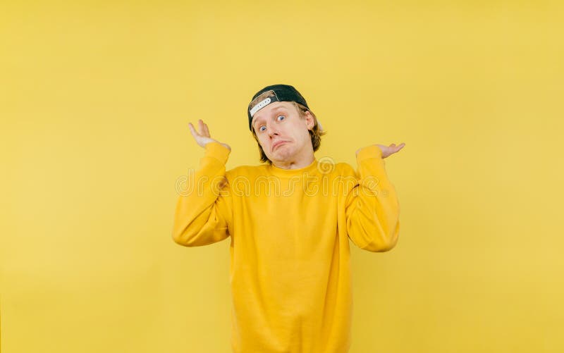Funny Scared Guy in a Cap on a Yellow Background Looks Puzzled at the ...