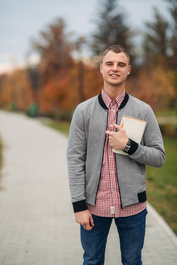 Funny Student with Notebook. Guy Stand in Park and Smile Stock Photo ...
