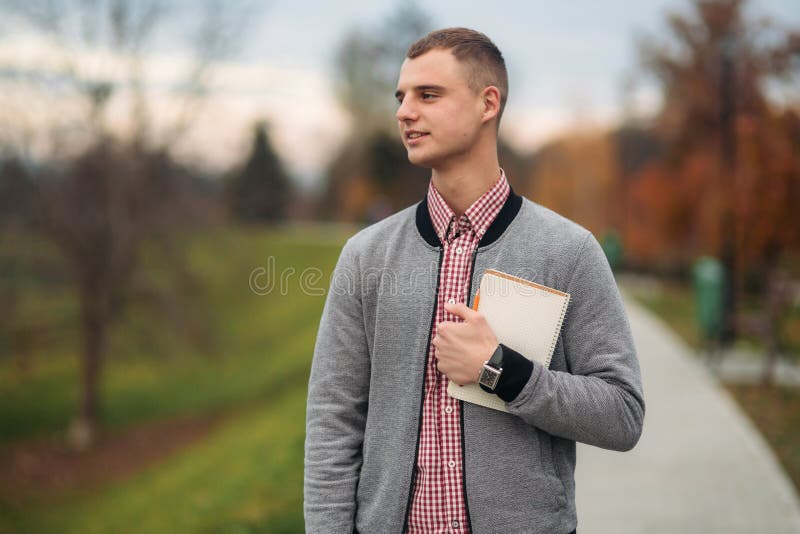 Funny Student with Notebook. Guy Stand in Park and Smile Stock Photo ...