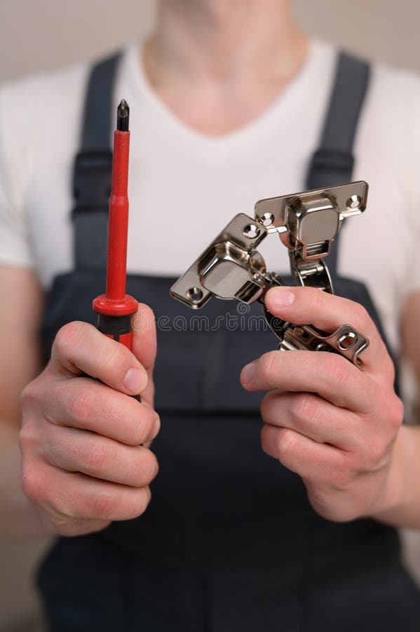 Furniture Assembler Holds a Furniture Hinge and a Screwdriver in His ...