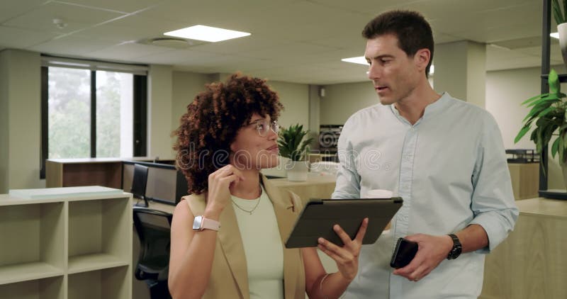 Furrowing Brow at Chart, Diverse Coworkers Walking Office Aisle Tapping ...