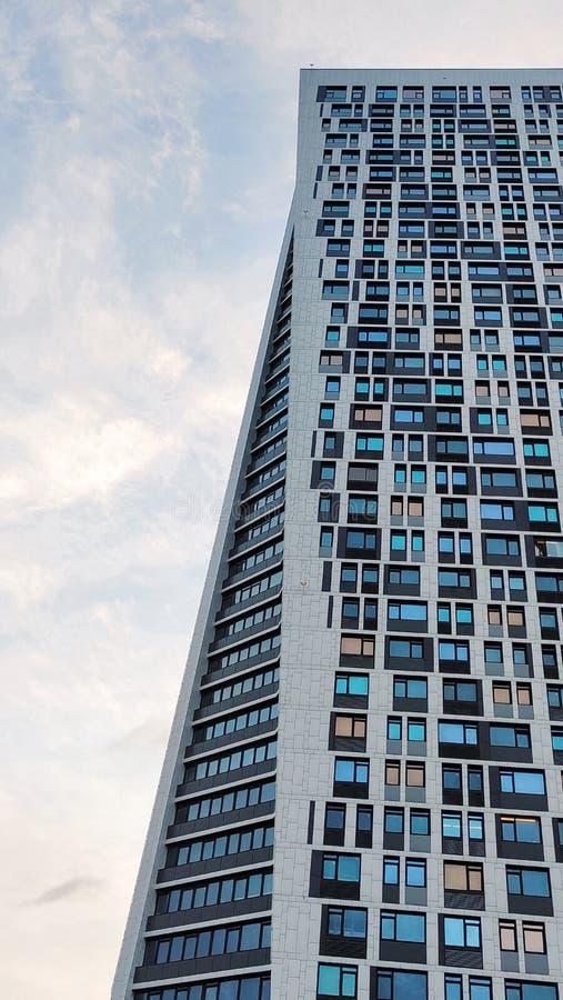 A Futuristic Skyscraper Against a Blue Sky. Part of the House is ...