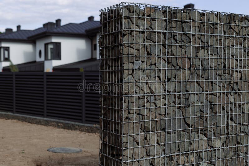 Gabion Fence. Posts Full of Stones with Sections from Wooden Planks ...