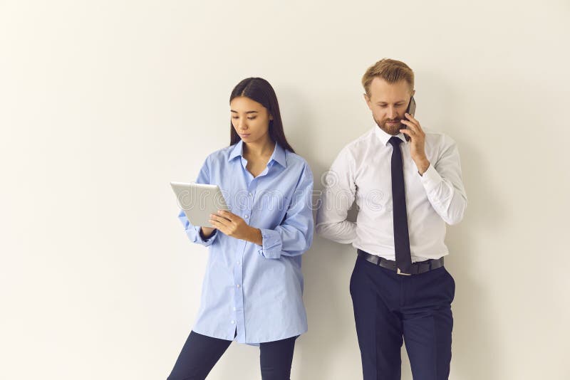 Two Coworkers Using Gadgets during Break at Work Completely Ignoring ...