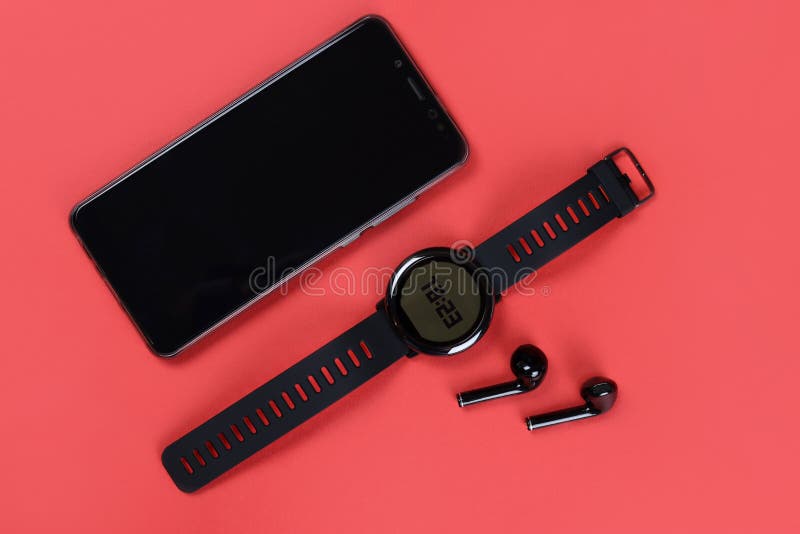Gadgets on a Red Background: Smartwatch, Bluetooth Headphones and Phone ...