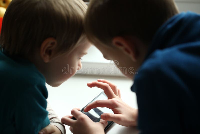 Game Addiction in Children Two Children Playing with a Smartphone while ...