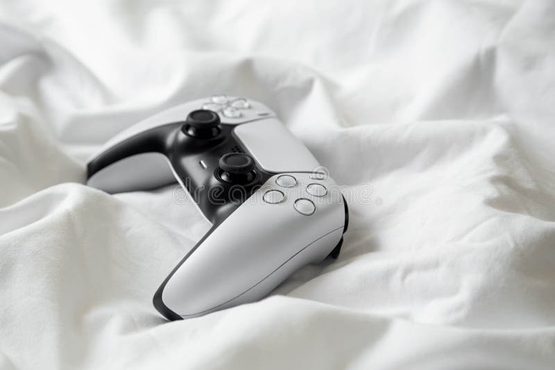 Game Controller, Lying on White Sheets of Bed at Home. Stock Photo ...