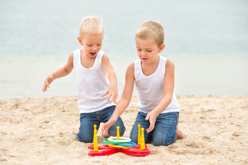 Two Brothers are Walking and Playing on the Beach.the Game is a Ring ...