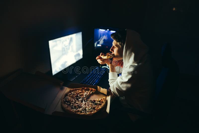 Gamer Sits at Home at Computer at Night, Uses the Computer and Eats ...