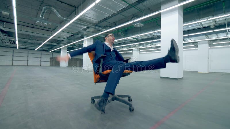 Gappy, Funny Office Manager is Riding on a Rolling Chair Across an ...