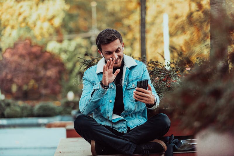 A Gappy Student Sitting in a Park Using a Smartphone and Wireless ...