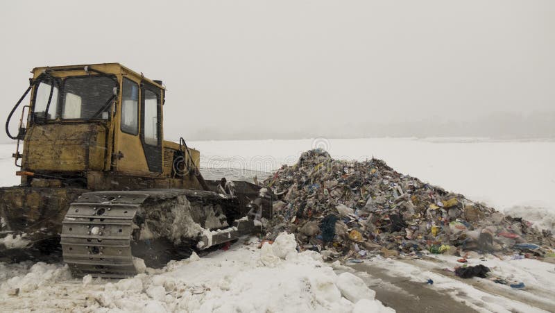 Garbage Dump in the Snow. Bulldozer Rakes a Bunch of Garbage Stock ...