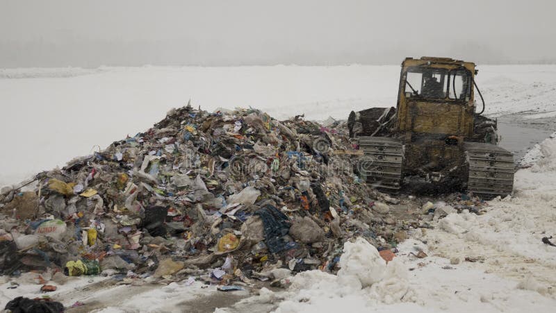 Garbage Dump in the Snow. Bulldozer Rakes a Bunch of Garbage Stock ...