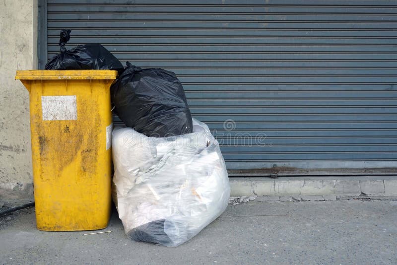 Garbage Dumpster and Trash Can in the Front Steel Fence of Building ...