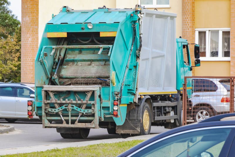 A Garbage Truck Picks Up Garbage in a Residential Area. Loading Mussar ...