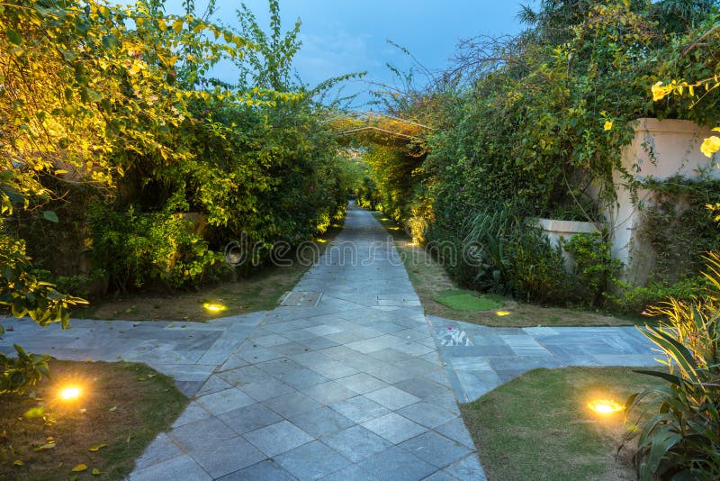Garden Path in Resort with Warm Light and Trees on Side at Evening ...