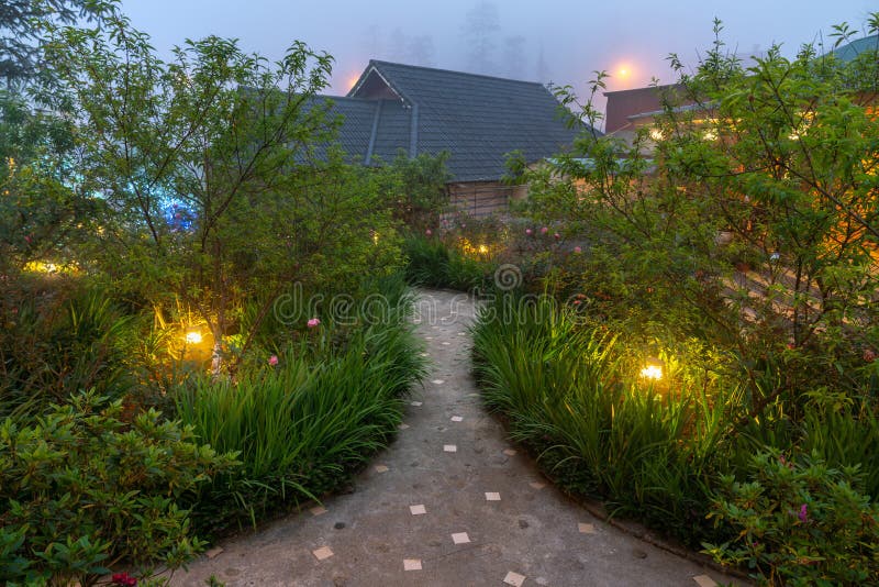 Garden Path in Resort with Warm Light and Trees on Side at Evening ...