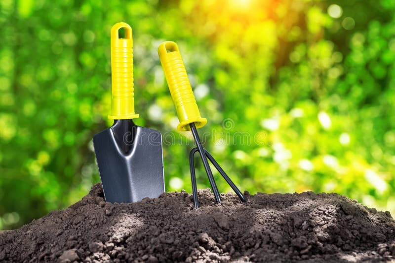Garden Tools Rake Shovel and Chopper on Pile of Earth Under Bright Sun ...