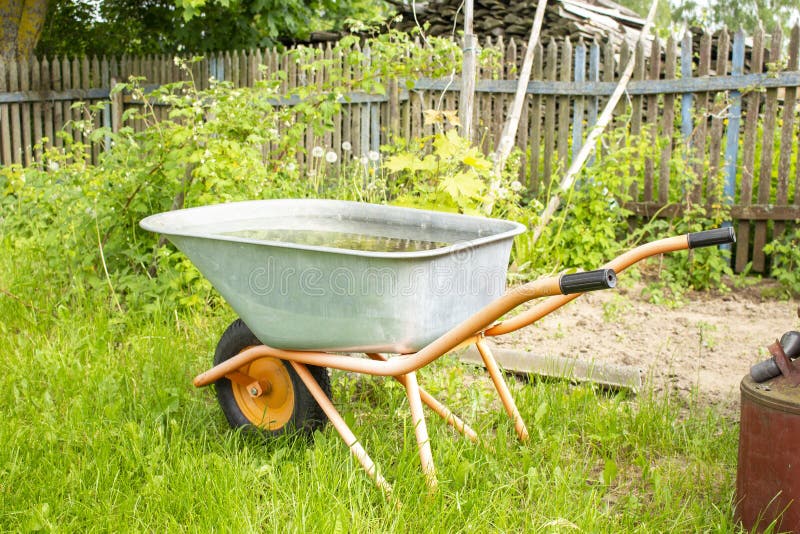 A Garden Wheelbarrow Stands in the Backyard of a Farm. Nearby ...