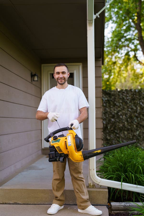 Gardener Man Clearing Up the Leaves Using a Leaf Blower Tool Stock ...