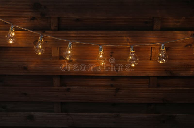Garland of Lamp Bulbs Hanging on Wooden Wall. String Lights Stock Image ...