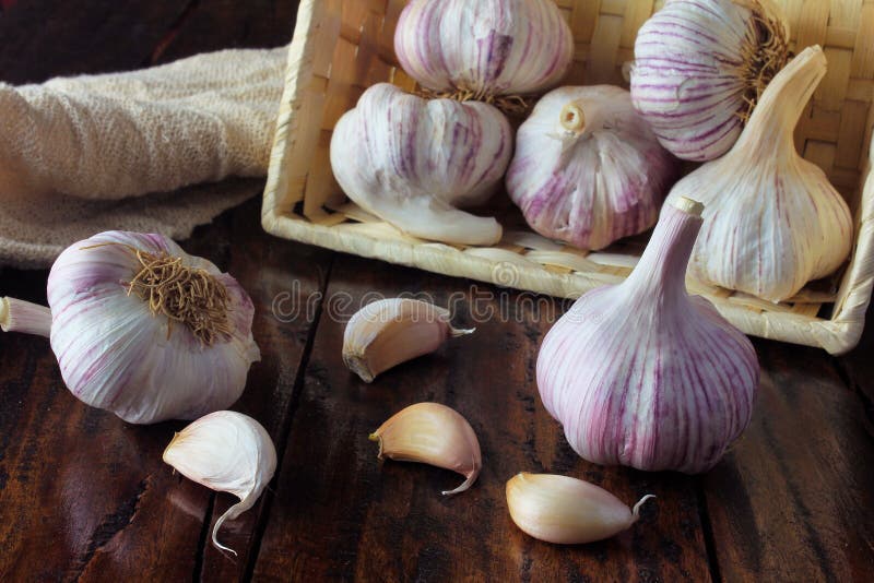 Garlic Bulbs Inside Basket of Straw, on Rustic Wooden Table. Closeup of ...