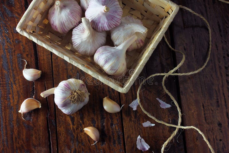 Garlic Bulbs Inside Basket of Straw, on Rustic Wooden Table. Closeup of ...