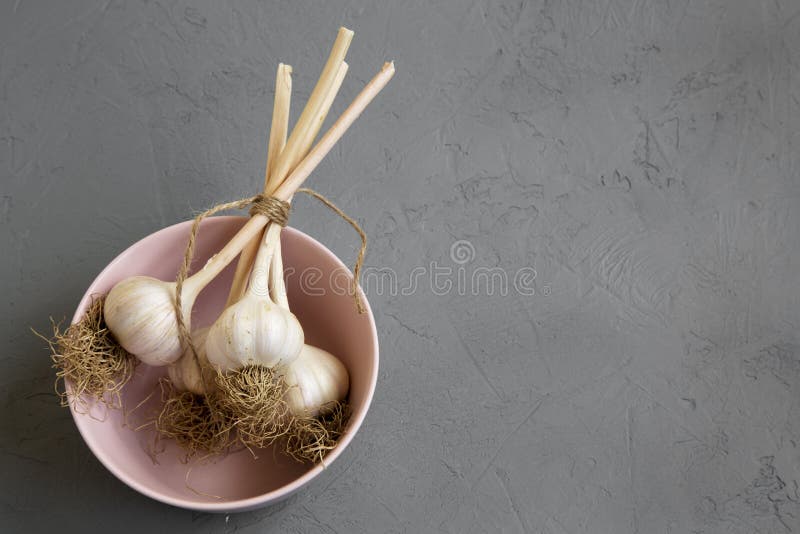 Garlic Bulbs in Pink Bowl Over Concrete Surface Stock Image - Image of ...