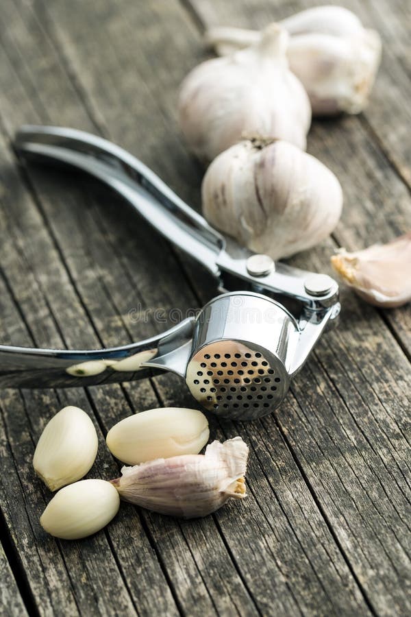 Garlic and garlic press. stock image. Image of metallic - 87540645