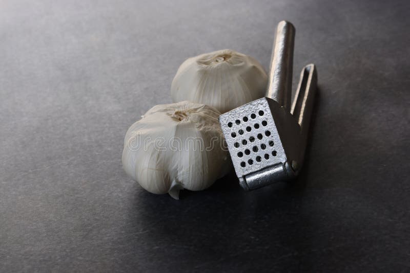 Garlic and Garlic Press Isolated on a Concrete Pattern Background Stock ...