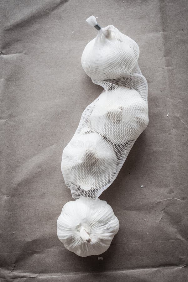 Garlic In White Net On Paper Background Flat Lay Stock Photo - Image of ...