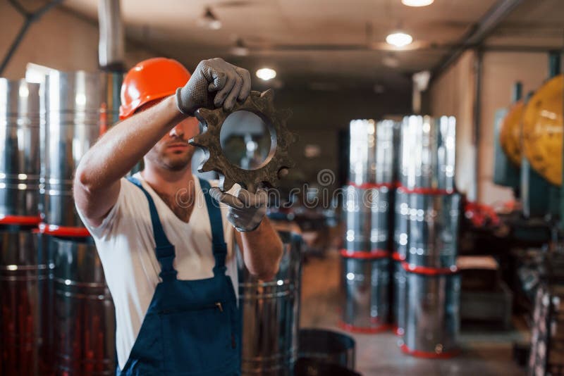 Gear in Hands. Man in Uniform Works on the Production Stock Photo ...