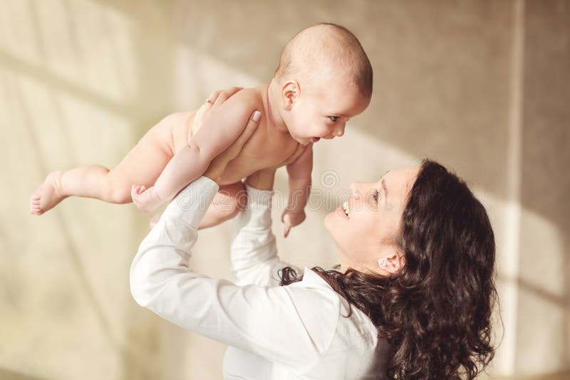 Gelukkige Moeder Die Haar Baby Houden En Met Hem Binnen Spelen Stock ... Gelukkige Moeder Die Haar Baby Houden En Met Hem Binnen Spelen Stock ...