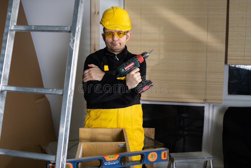A General Construction Worker with a Cordless Screwdriver in Hand is ...