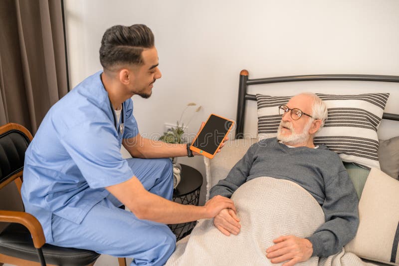 General Practitioner Examining a Bedridden Man during the Home Visit ...