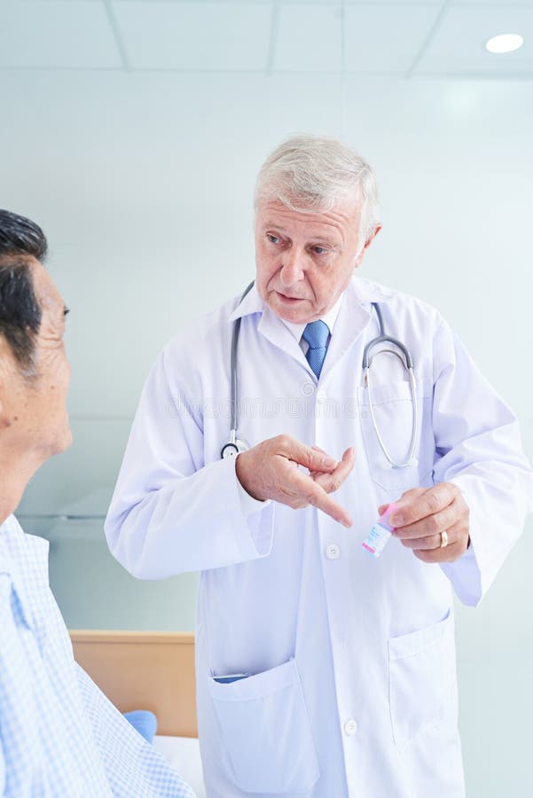 General Practitioner Giving Medicine To Senior Patient Stock Photo ...