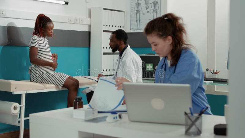 General Practitioner Taking Notes on Documents at Appointment Stock ...