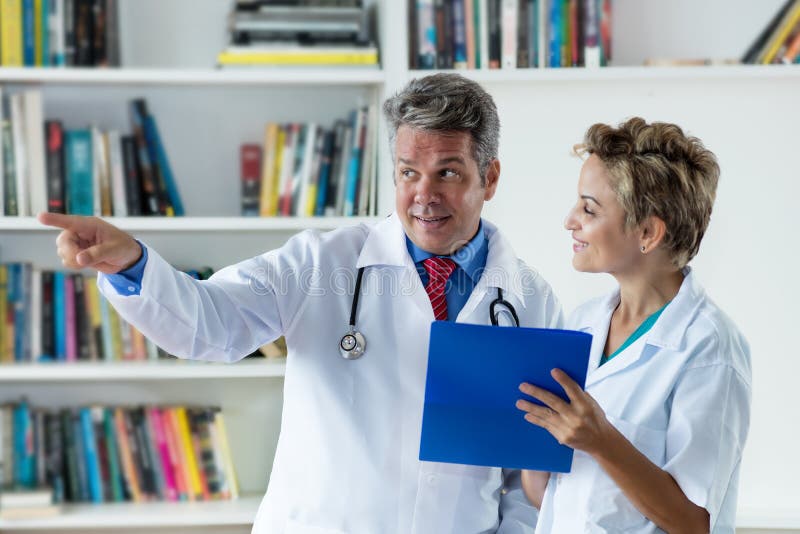 General Practitioner Talking about Patient with Female Doctor Stock ...