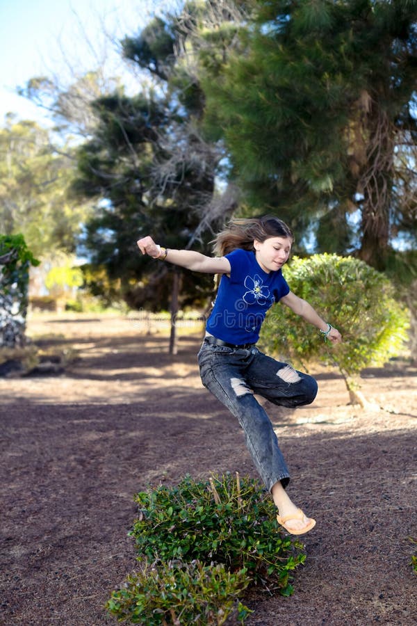 Beautiful Young Girl Leaping Over Plants in a Garden Stock Photo ...